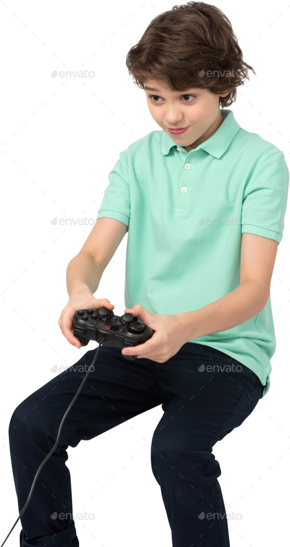 a young boy sitting on a chair holding a video game controller Stock ...