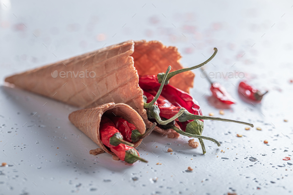 Spicy ice cream. Chilli peppers in ice cream cone. Stock Photo by Shaiith