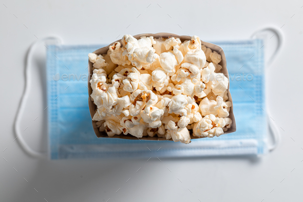 Coronavirus and protective in cinema. Mask and popcorn box. Stock Photo ...