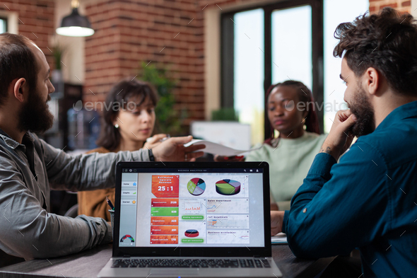 Laptop computer with marketing graphs on screen Stock Photo by DC_Studio