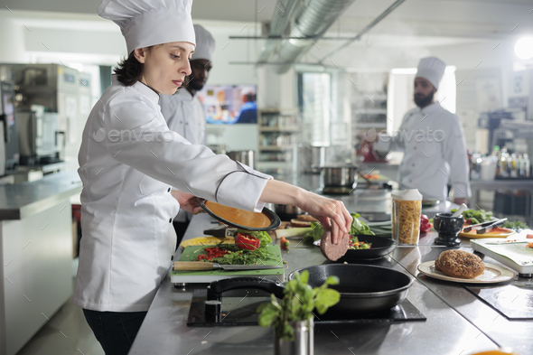 Food industry worker cooking beef patty in pan while preparing ...