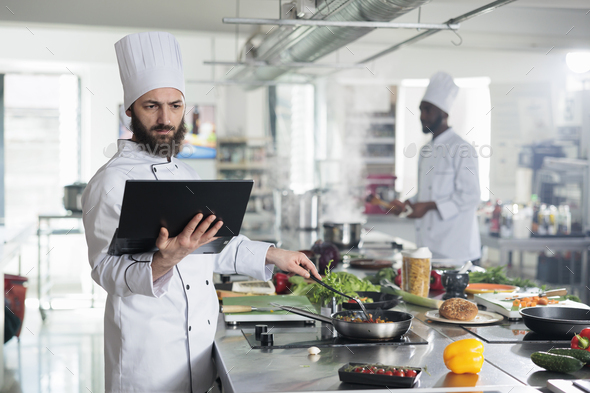 Head cook with computer brainstorming gourmet dish recipes for food ...