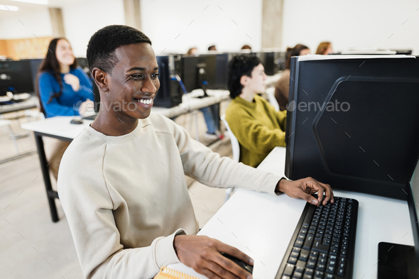 Young african student using computer inside college room at school ...