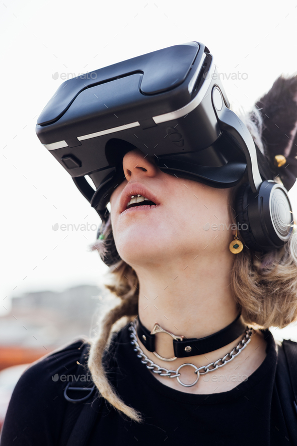 Rebel young diverse woman outdoor addicted to metaverse using three ...