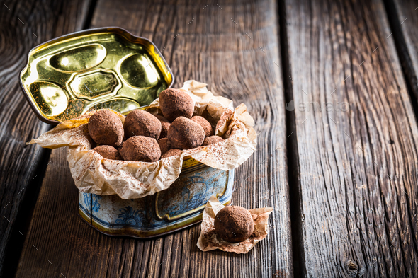 Chocolate balls in blue box sprinkled with cocoa Stock Photo by Shaiith