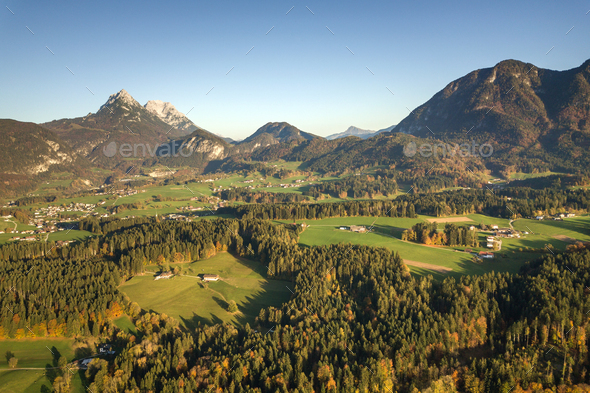 Aerial view of green meadows with villages and forest in austrian Alps ...