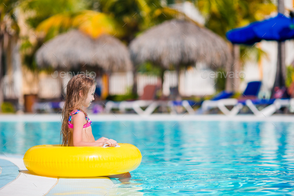 Little active adorable girl in outdoor swimming pool ready to swim ...