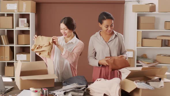 Women Sorting through Clothes and Packing Orders, Stock Footage | VideoHive