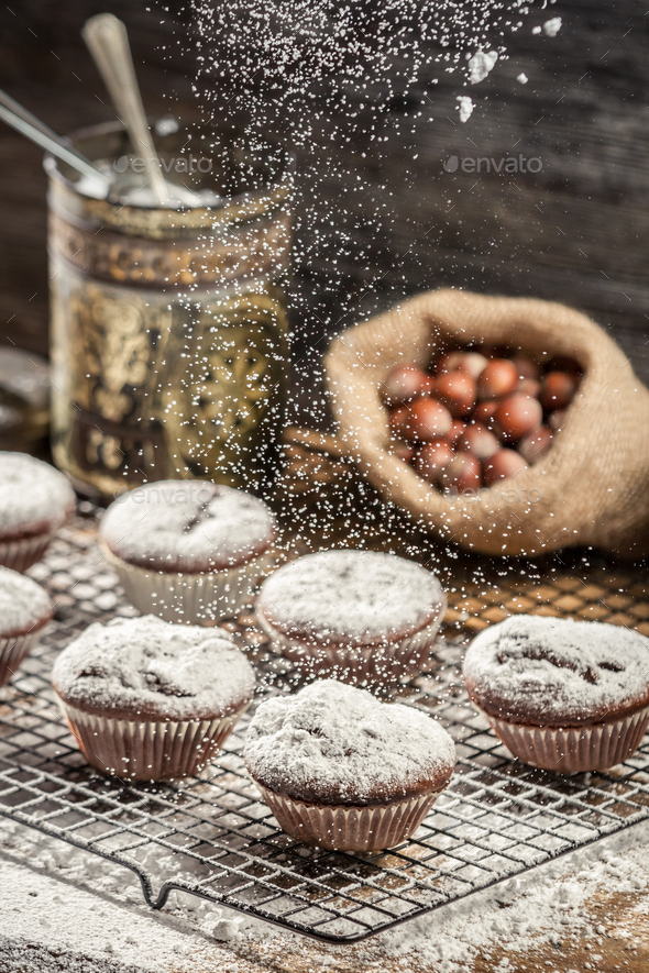 Falling icing sugar on fresh chocolate muffins Stock Photo by Shaiith