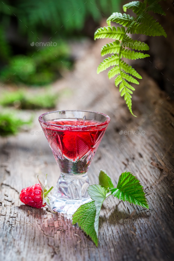 Fresh raspberries liqueur made of fruits and alcohol Stock Photo by Shaiith
