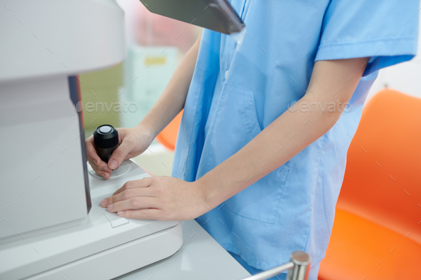 Ophthalmic Nurse Using Modern Equipment Stock Photo by DragonImages