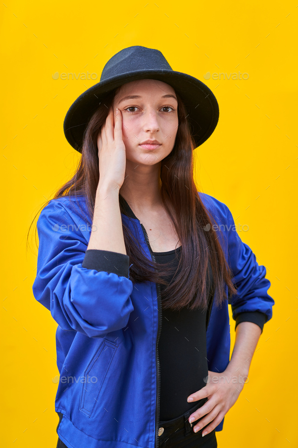 Vertical photo portrait of a young caucasian girl on yellow background ...
