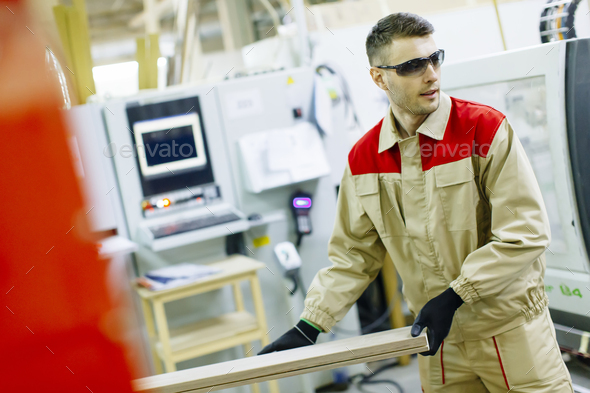 Craftsman wearing working clothes and protective eyewear woodworking ...