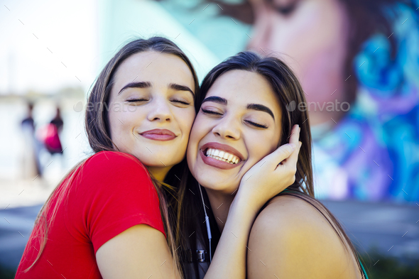 Two best female friends embracing together Stock Photo by BGStock72