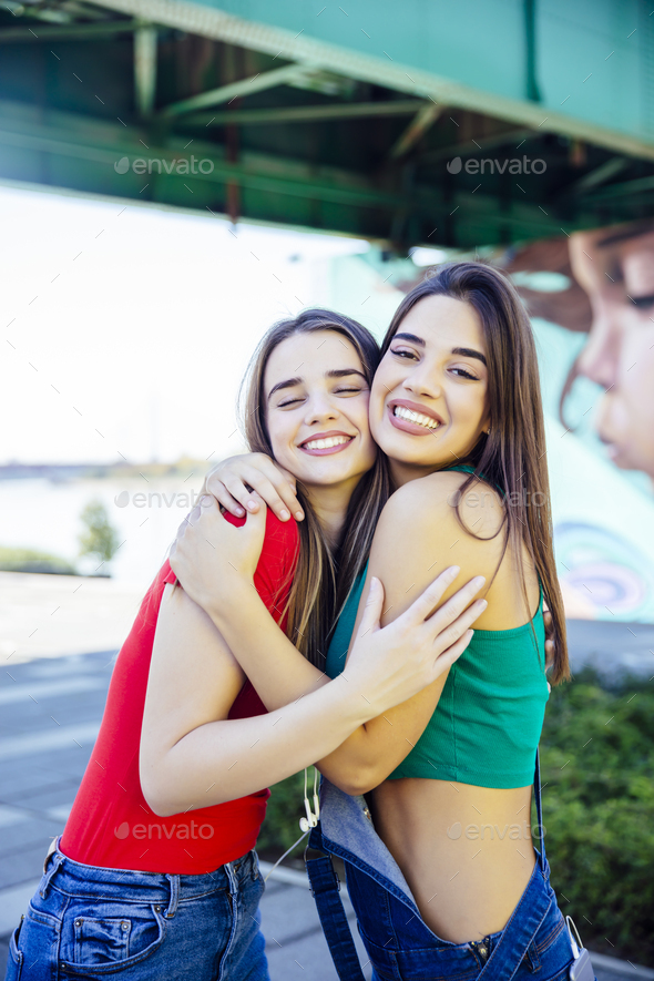 Two best female friends embracing together Stock Photo by BGStock72