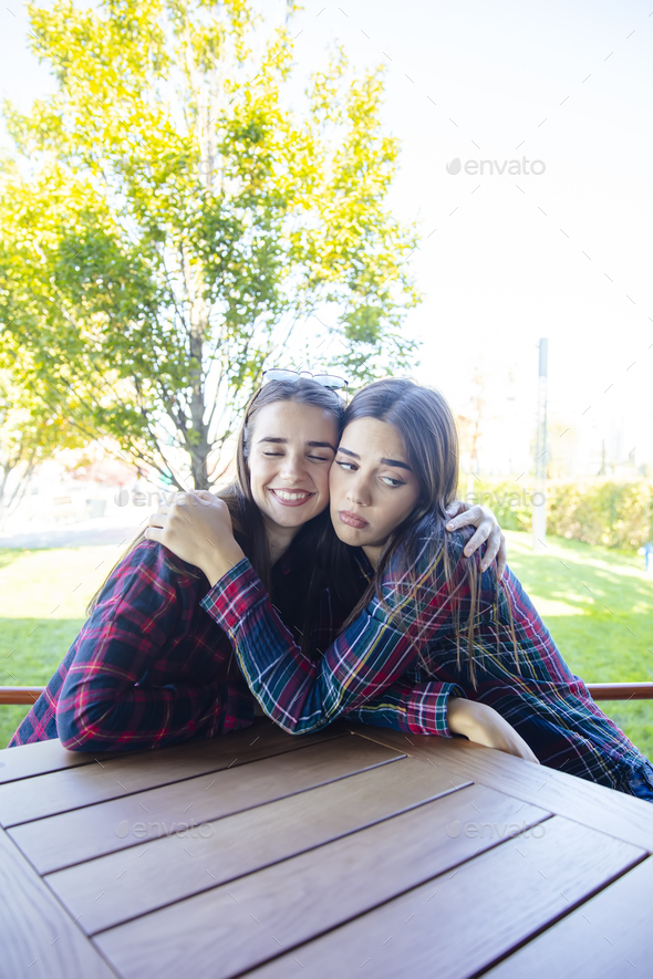 Two sad best female friends embracing each other Stock Photo by BGStock72