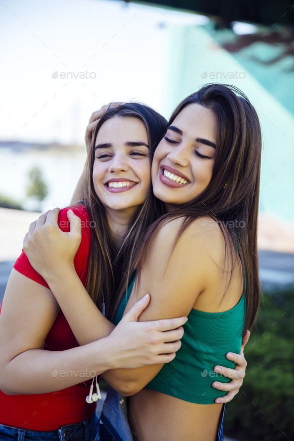 Two best female friends embracing together Stock Photo by BGStock72