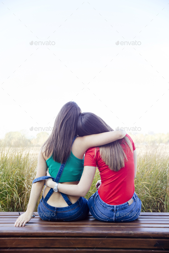 Two best female friends embracing together Stock Photo by BGStock72