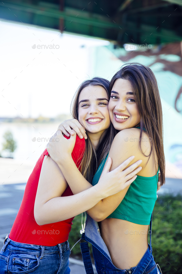 Two best female friends embracing together Stock Photo by BGStock72