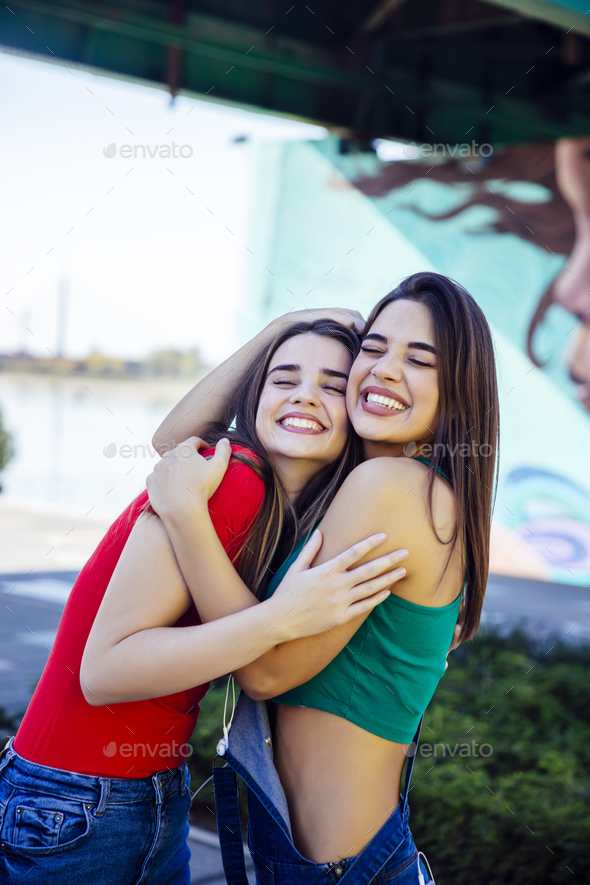 Two best female friends embracing together Stock Photo by BGStock72