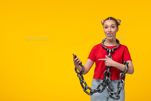 female vampire with heavy chains around her neck using her phone yellow ...
