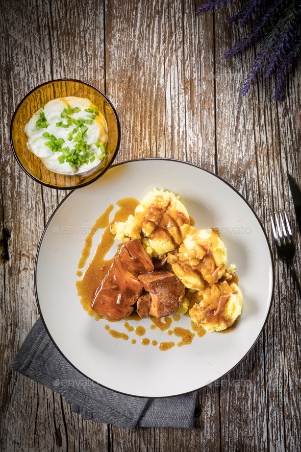 Braised pork neck in own sauce served with boiled potatoes. Stock Photo ...