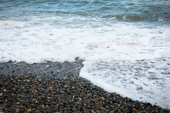 Seascape. Blue and gray pebbles on the beach. White sea waves.Skyline ...