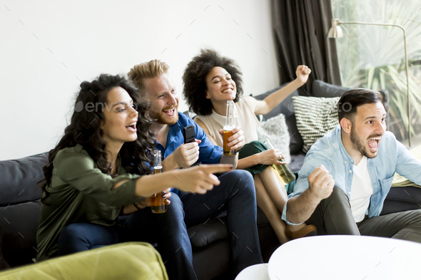 Group of friends watching TV, drinking cider and having fun Stock Photo ...