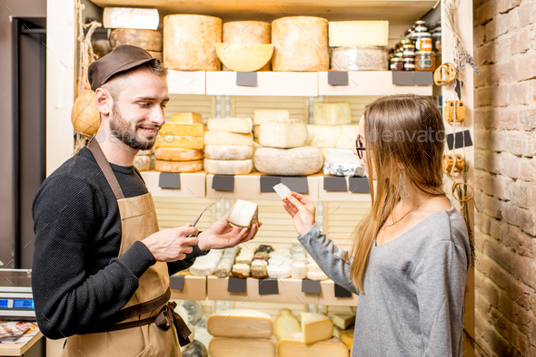 Cheese seller with a customer Stock Photo by RossHelen | PhotoDune