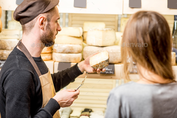 Cheese seller with a customer Stock Photo by RossHelen | PhotoDune