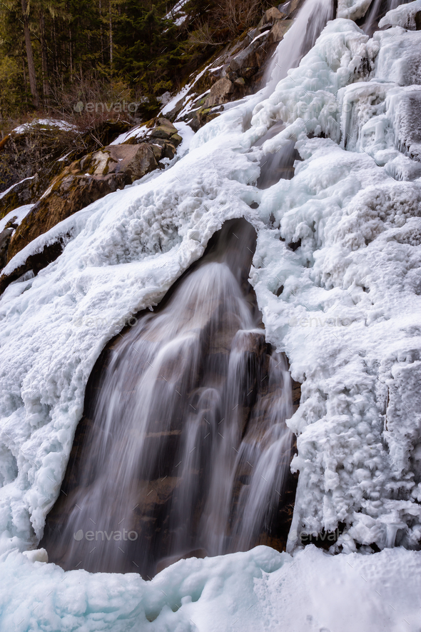 View of a waterfall, Crooked Falls, covered in melting ice during ...