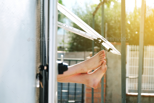 Relaxed woman sticking her feet out of a caravan window Stock Photo by ...