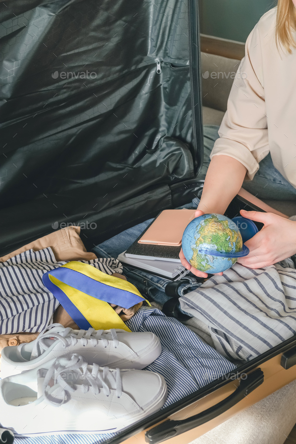Ukraine military migration. A suitcase with things and a flag of ...