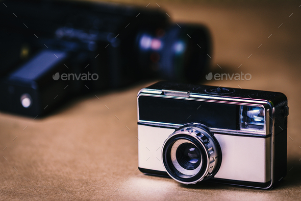 Vintage gray photo camera with brown background with an unfocused video ...