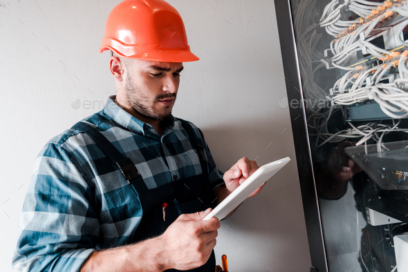 handsome workman using digital tablet near cables and wires Stock Photo ...
