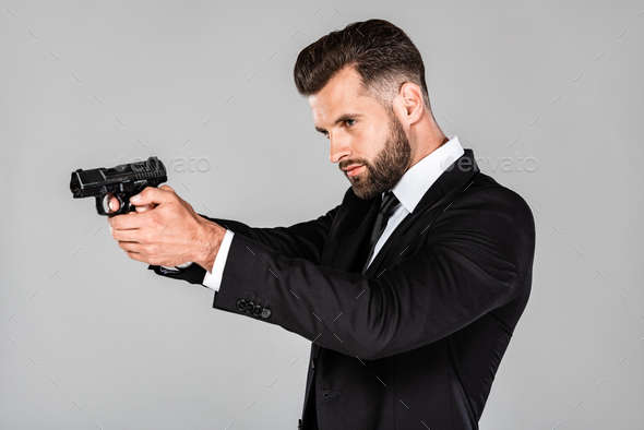 handsome agent in black suit aiming gun isolated on grey Stock Photo by ...