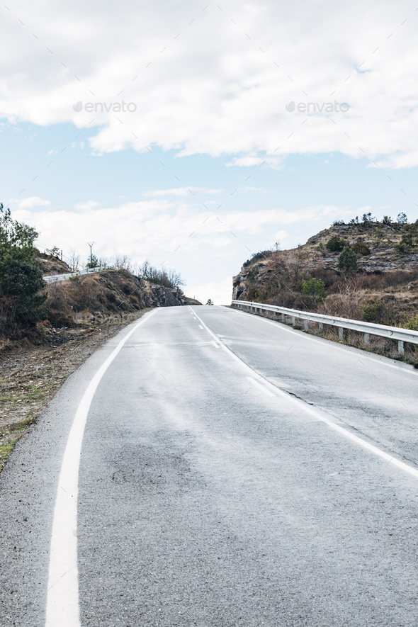 Asphalt road going up a mountain and disappearing into the horizon ...