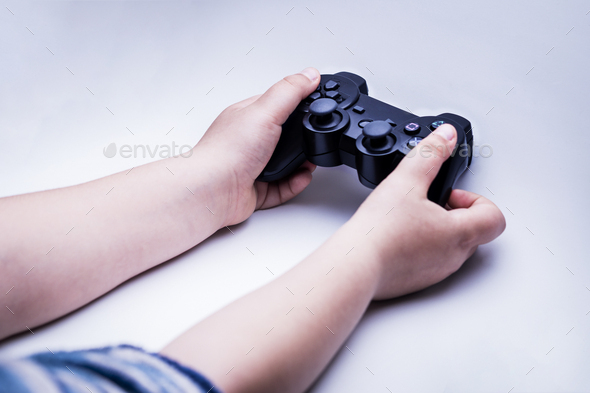 Child hands playing with the black remote of a console. Stock Photo by ...