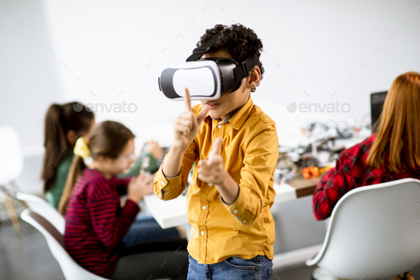 Cute little boy wearing VR virtual reality glasses Stock Photo by BGStock72