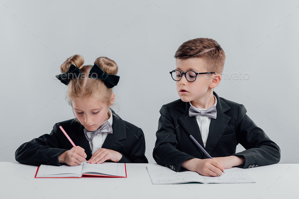 education. little boy trying to copy off a schoolgirl test paper, Stock ...