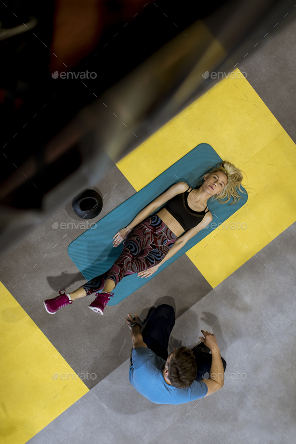 Top view at sporty woman exercises with assistance of her personal ...