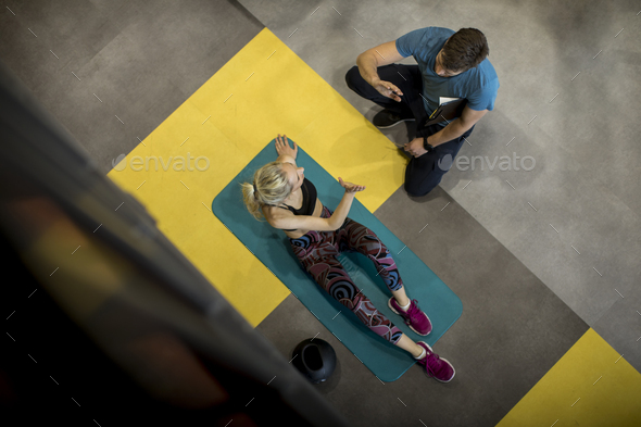 Top view at sporty woman exercises with assistance of her personal ...