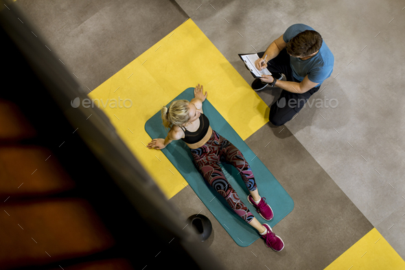 Top view at sporty woman exercises with assistance of her personal ...