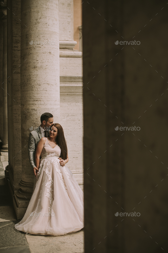 Young newly married couple posing in Rome with beautiful and ancient ...