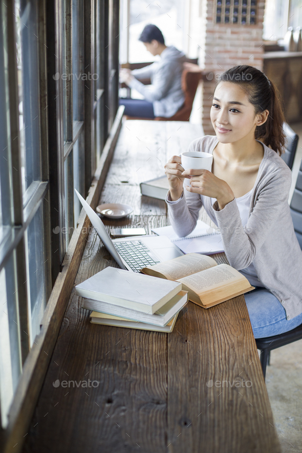 Young woman studying in cafe Stock Photo by bluejeanimages | PhotoDune