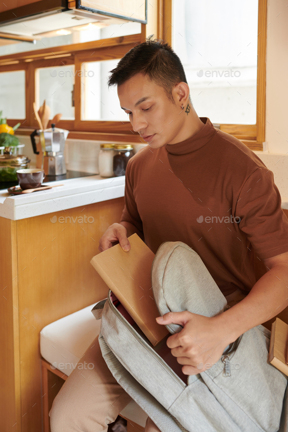 Student Putting Books in Backpack Stock Photo by DragonImages | PhotoDune