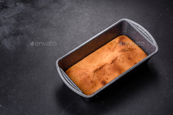 Baked rectangular cupcake with raisins and chocolate on a dark concrete ...