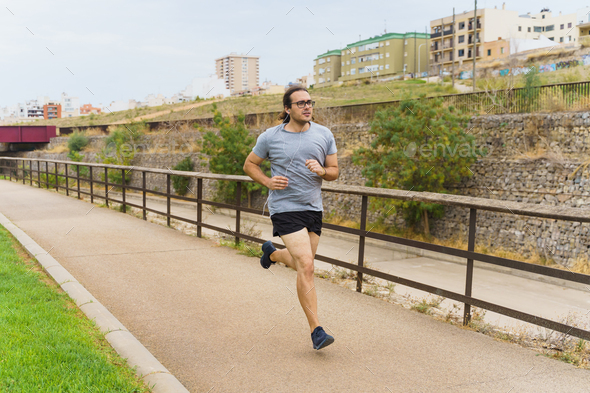 White man with long hair running in park and smiling. Sport Concept ...