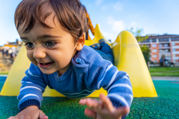 One year old Caucasian boy smiling and playing swings, playing in the ...