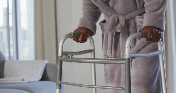 Mid section of senior man using zimmer frame to walk at home, Stock Footage